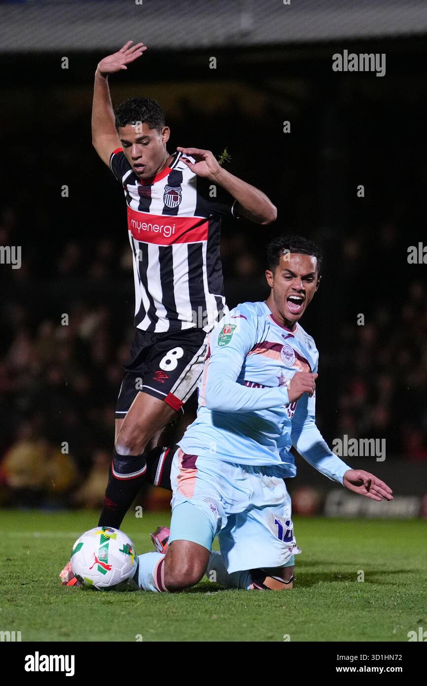 Grimsby Town's Evan Khouri (left) fouls Brentford's Fabio Carvalho and ...