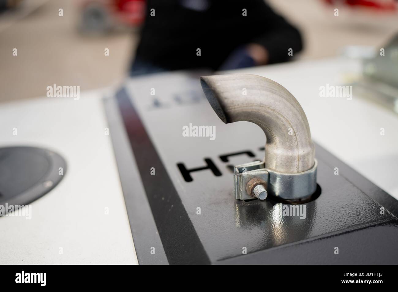 Metal pipe outlet on machinery surface representing industrial ...