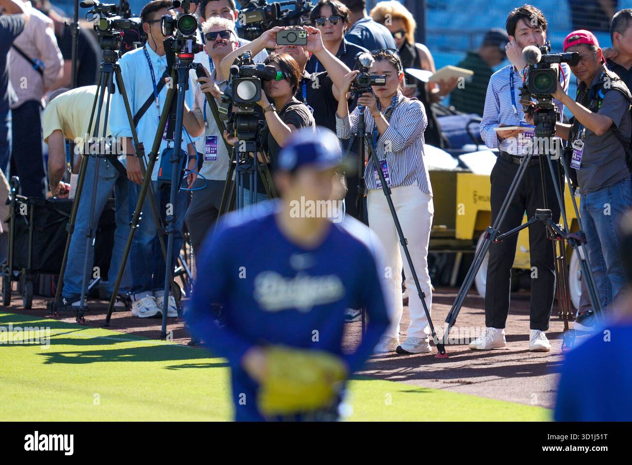Media members watch Los Angeles Dodgers' pitcher Roki Sasaki warm up ...
