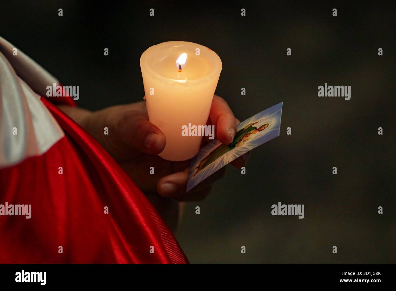 A devotee of Saint Jude Thaddeus lights a candle at the Church of San ...