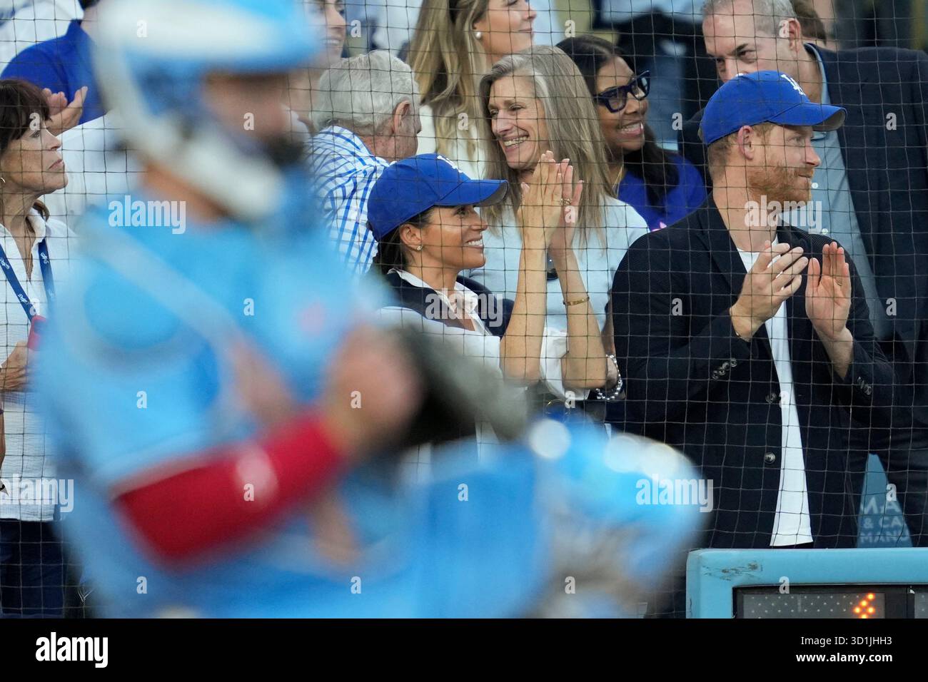 Prince Harry and Meghan Markle watch during the second inning in Game 4 ...