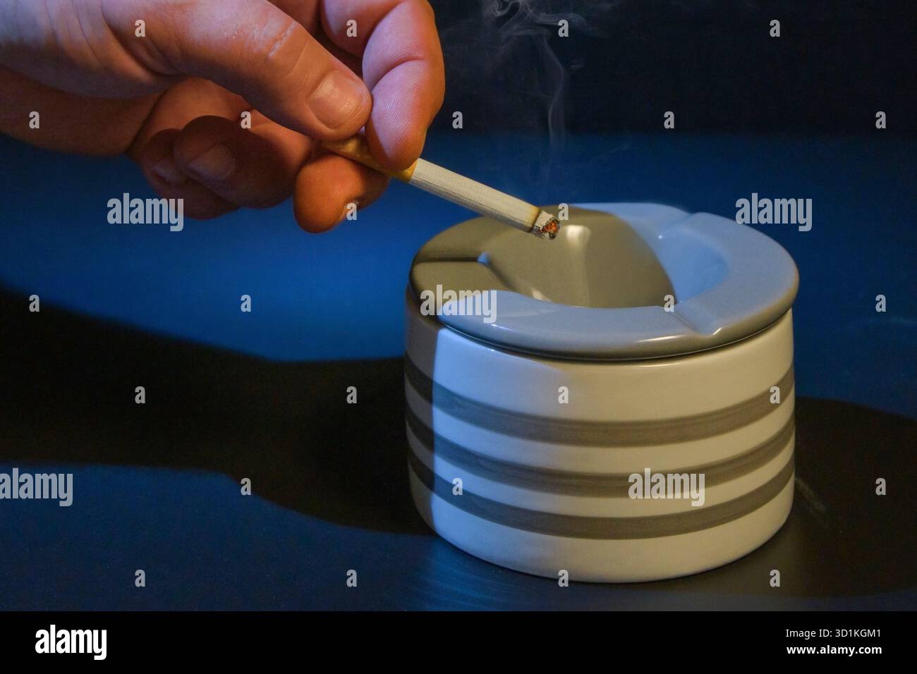 Male hand with smoking cigarette over ashtray close-up Stock Photo - Alamy