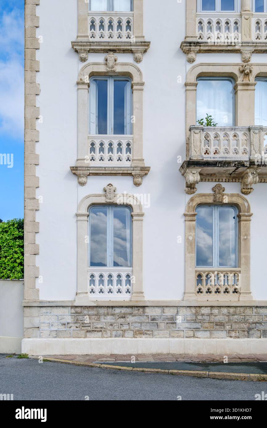 White Plaster Facade with Ornate Carved Stone Windows and Balcony in ...