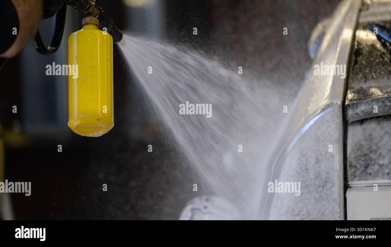 Close up of a worker using a high pressure spray bottle to apply foam ...
