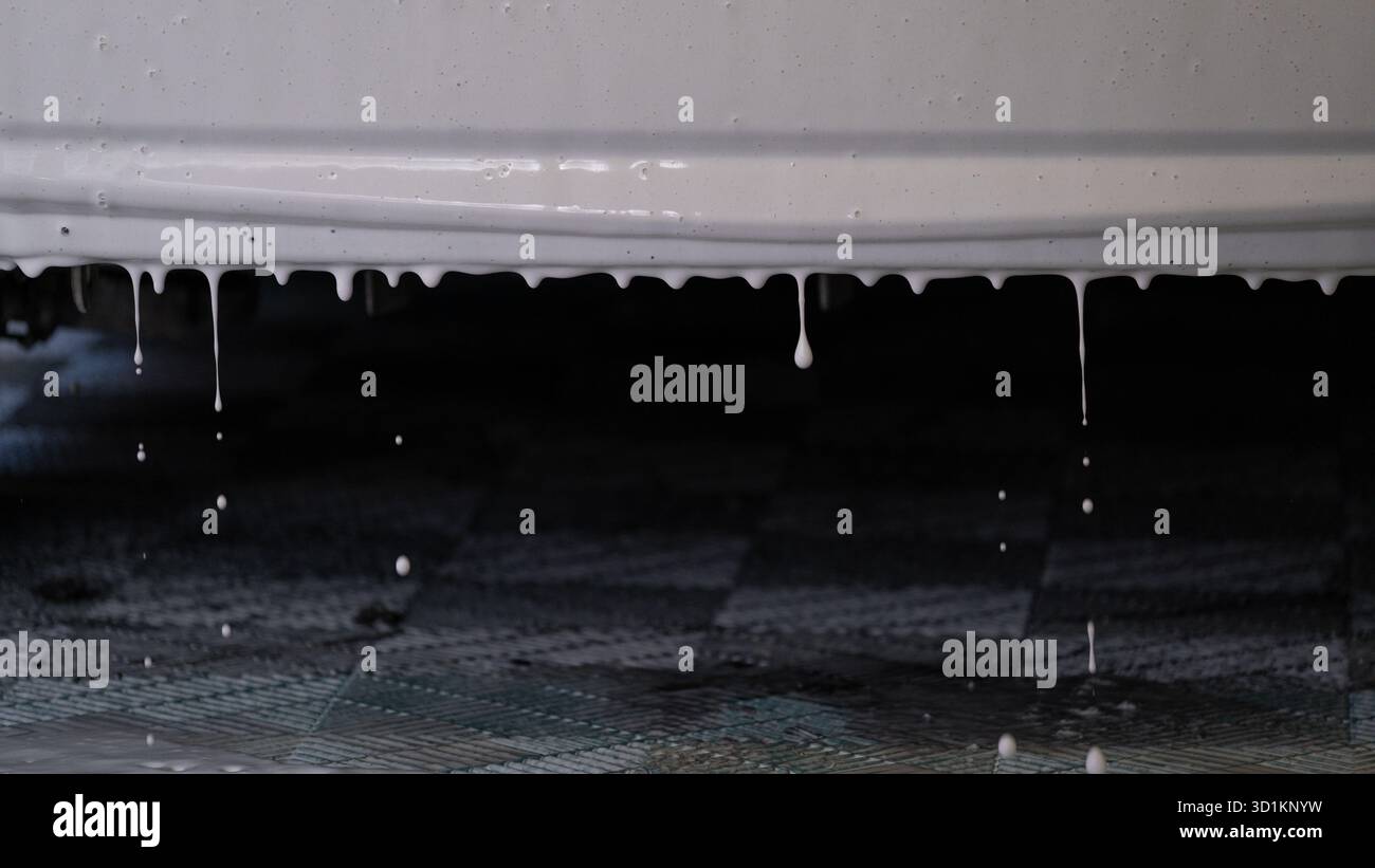 Close-up of foam dripping from the lower part of a car during a ...