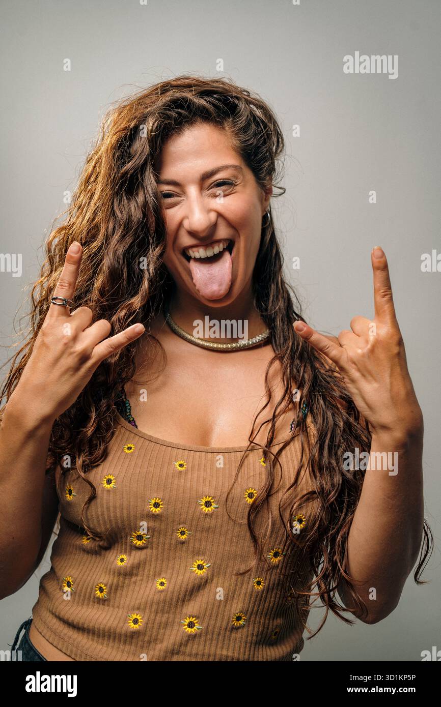 With wild curls and a confident smile, a young woman boldly displays ...