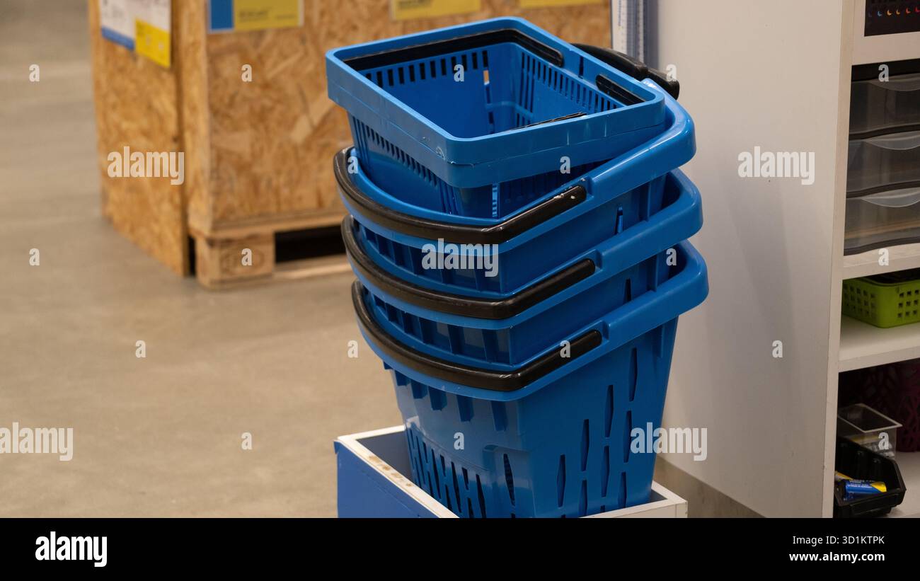Stack of blue plastic shopping baskets inside a retail store ...