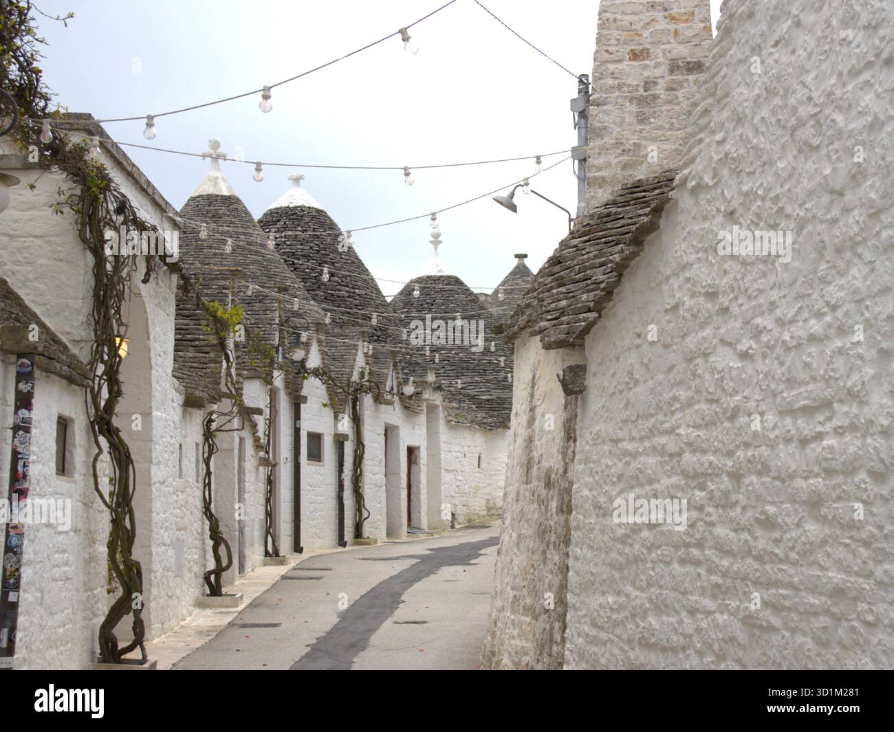 A quiet, narrow lane curves between whitewashed stone houses capped ...
