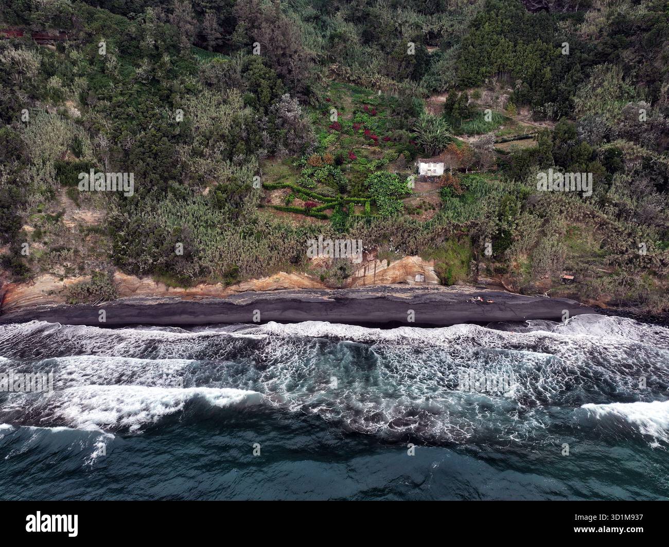 Aerial view of the dark, volcanic sand meeting the turquoise waves at ...