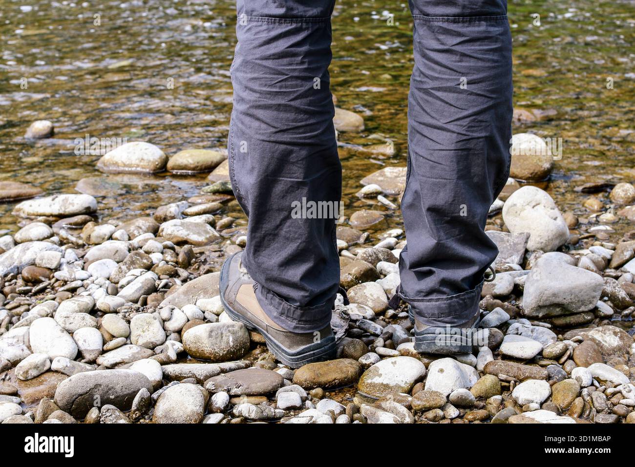 Traveller walking at the riverside. Hiking boots on bedrock Stock Photo ...