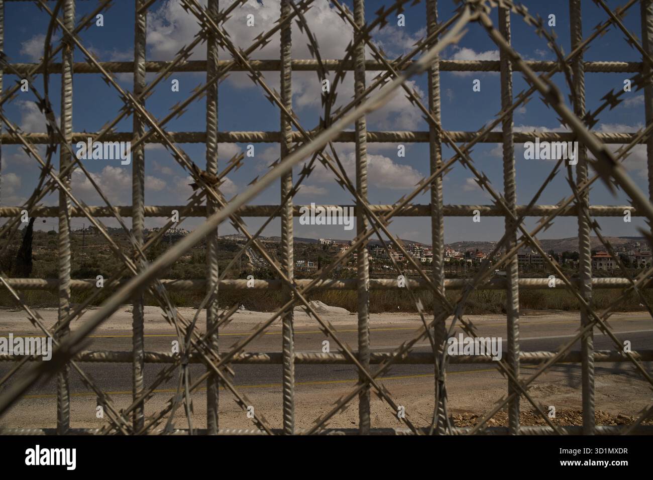 The town of Turmus Ayya is seen through a fence built by Israeli ...