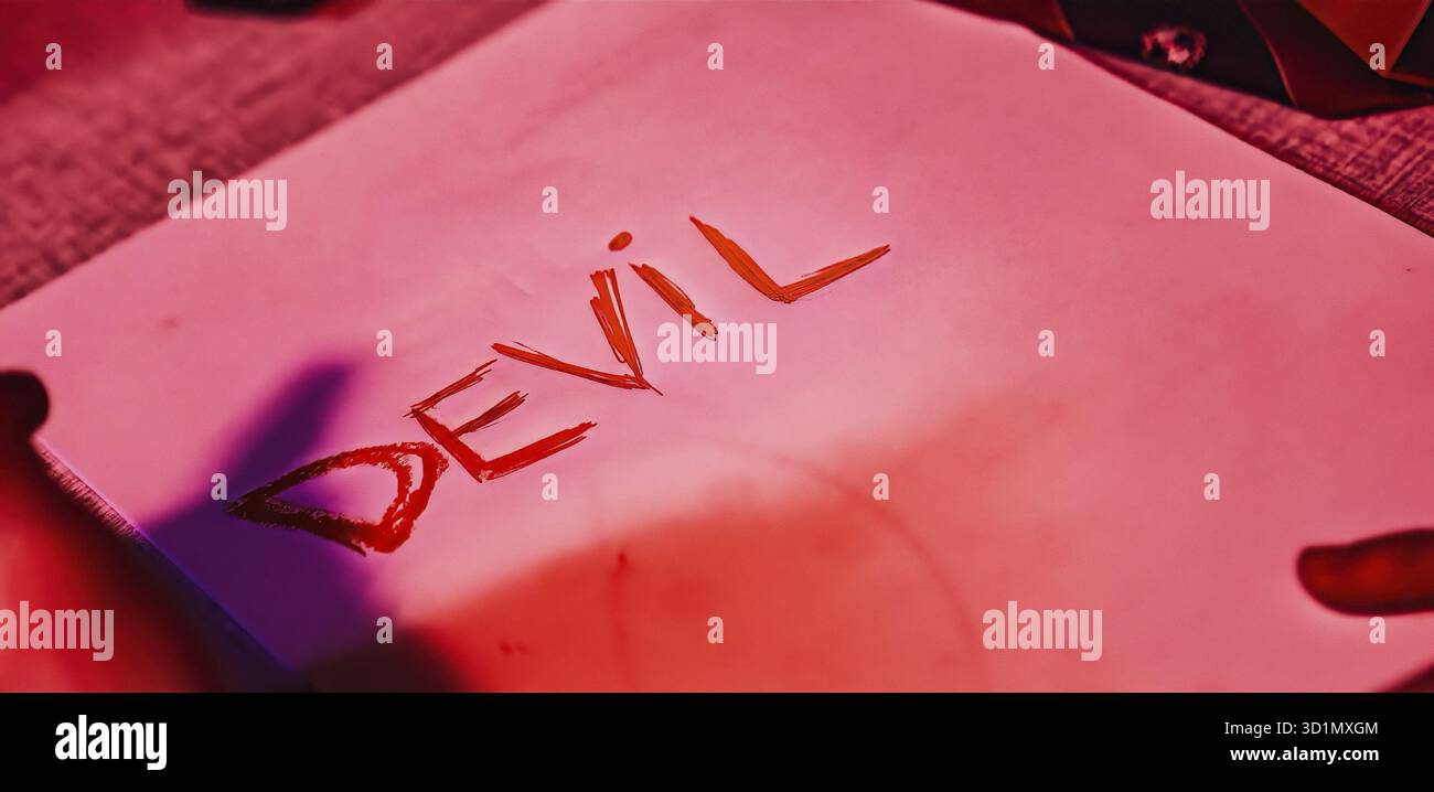 A close-up shot of a paper with the word 'Devil' written in cursive ...