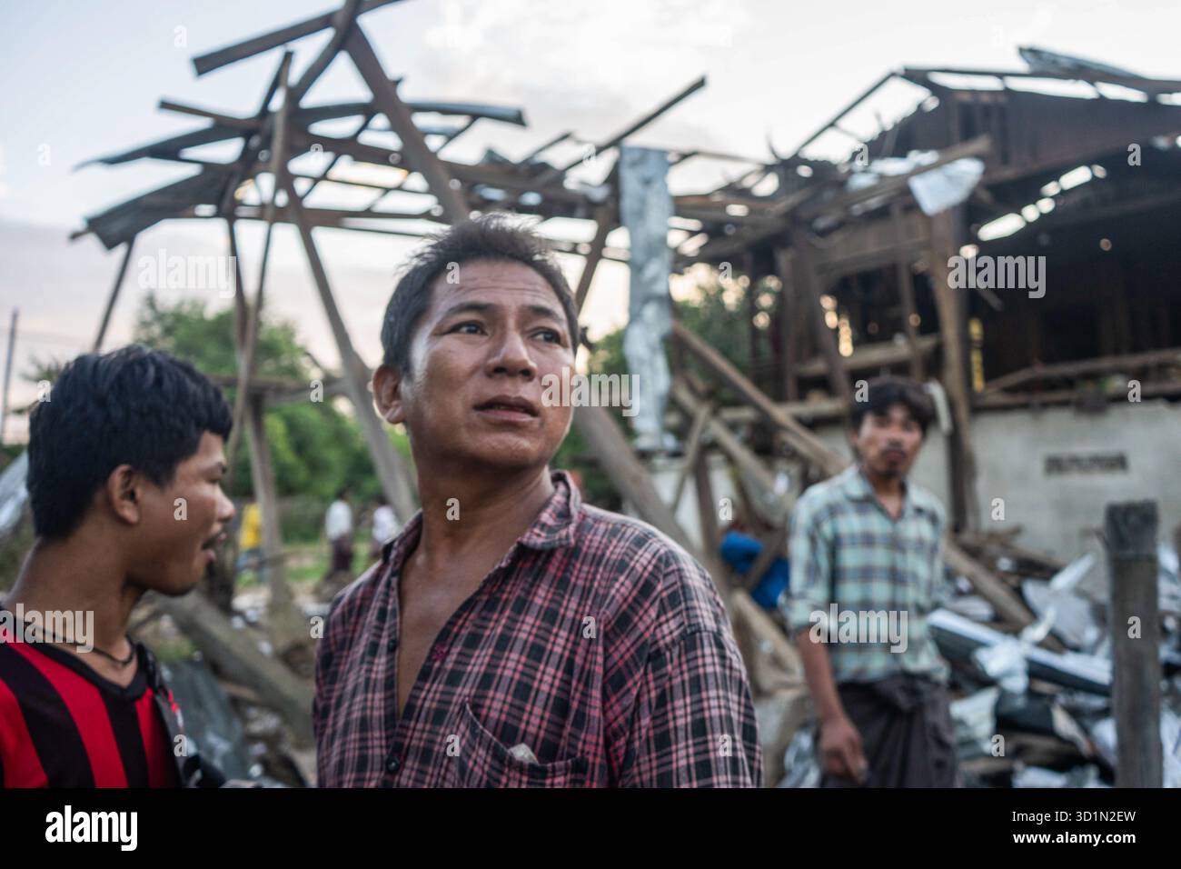 Local villagers walk through the ruins of a house damaged by an ...