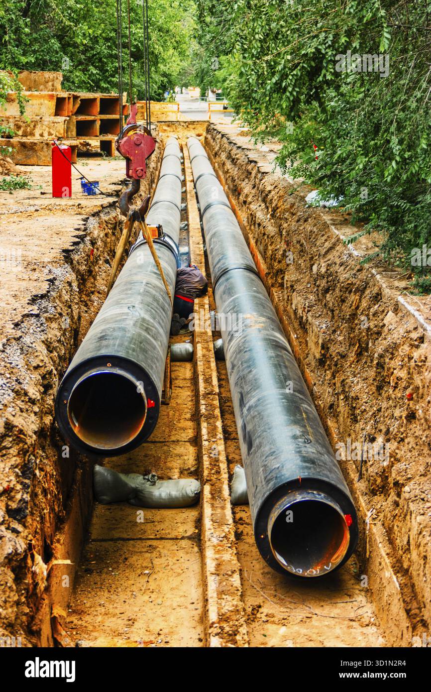 Two New heating water tube pipe in trench covered with black heat ...