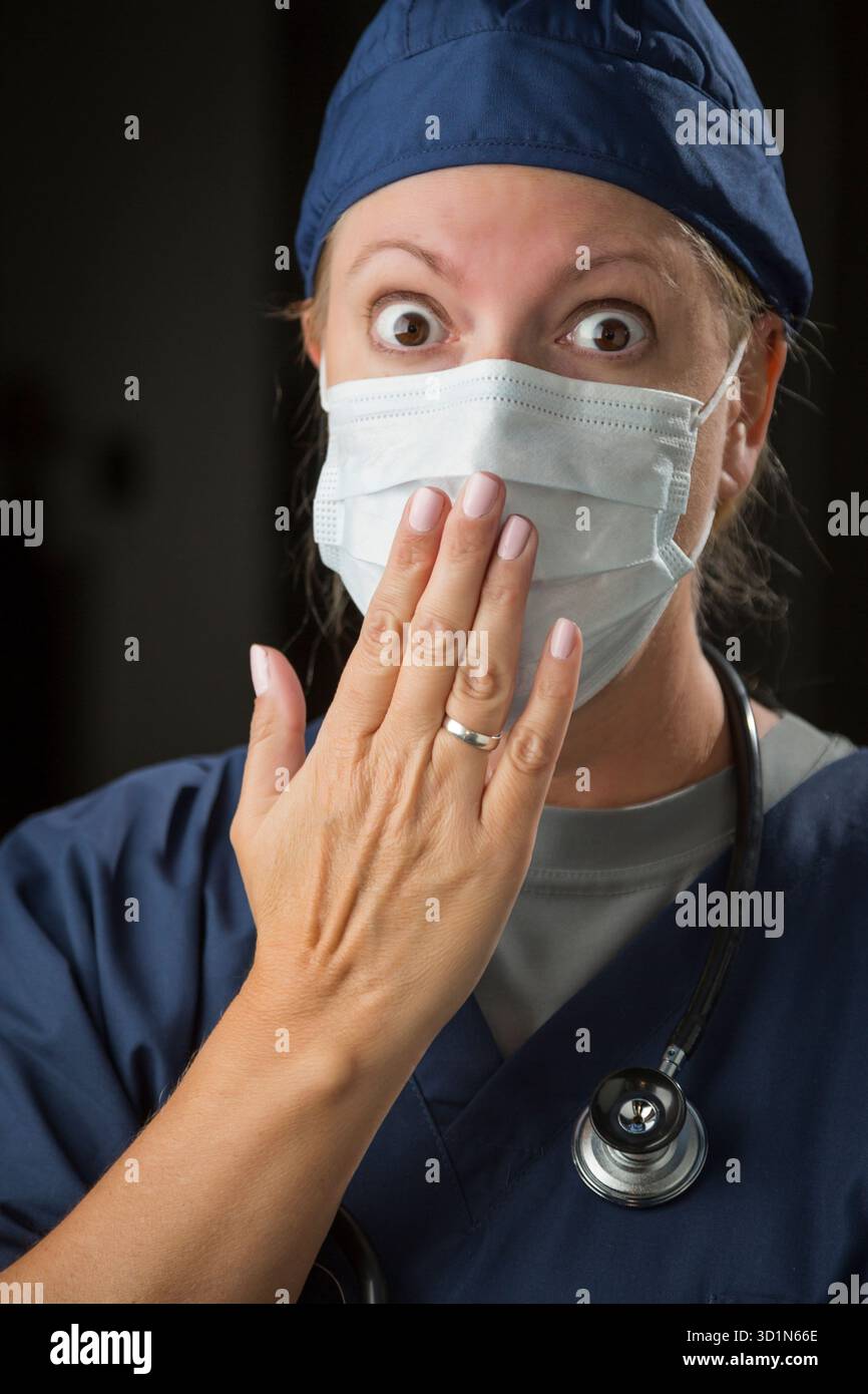 Shocked Female Doctor with Hand in Front of Mouth Stock Photo - Alamy