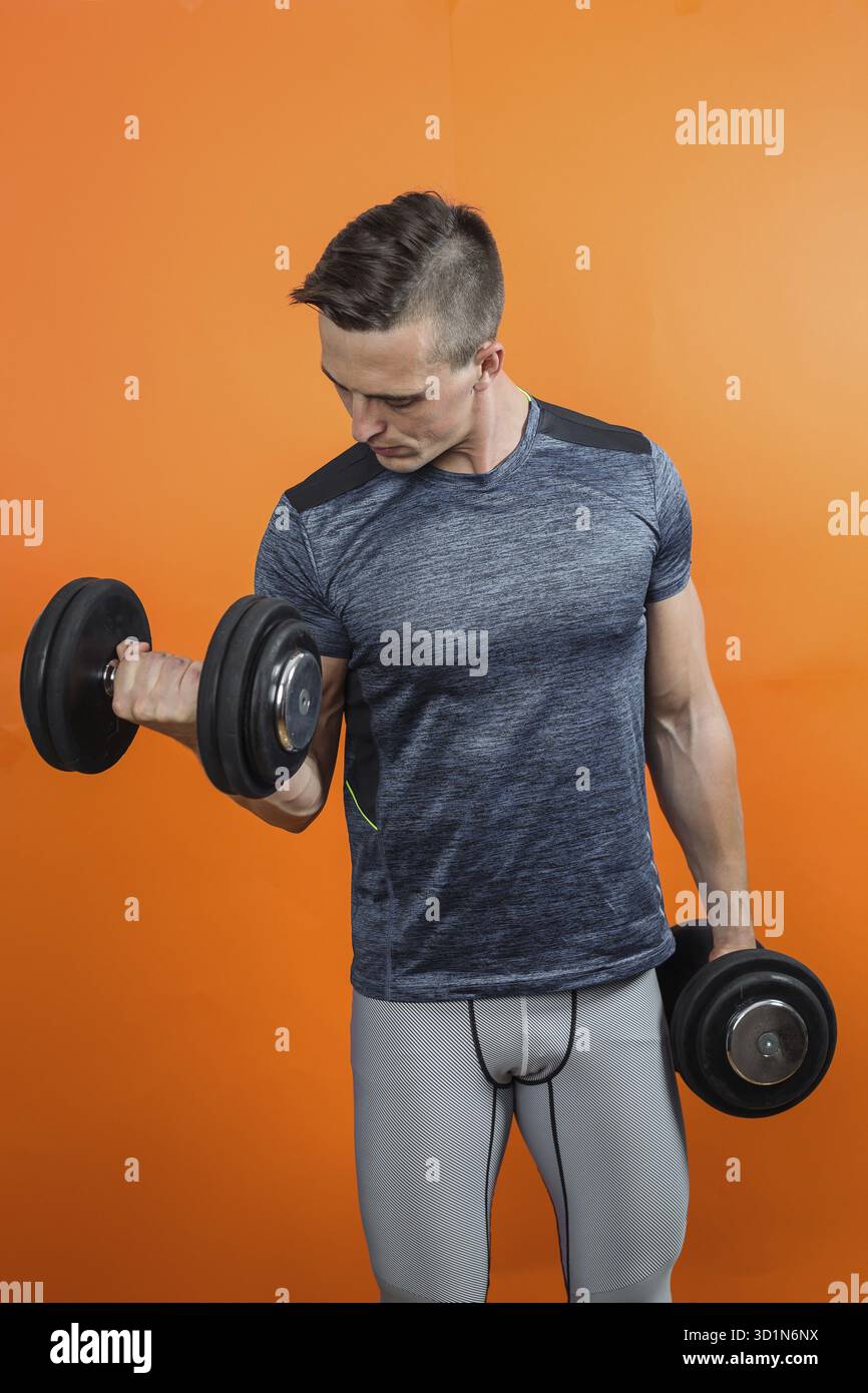 Strong and muscular guy with dumbbells Stock Photo - Alamy