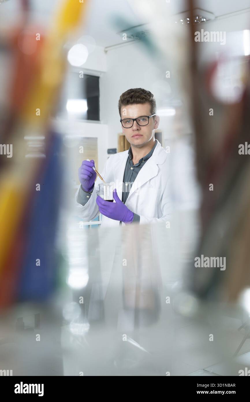 Modern chemist looking at liquid in flask in laboratory Stock Photo - Alamy