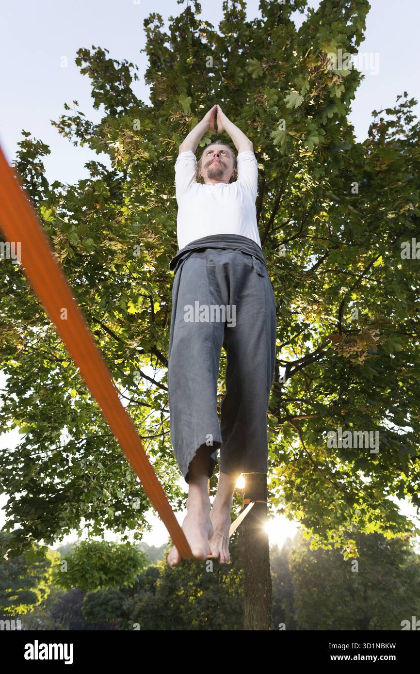 Guy practising slack line in the city park Stock Photo - Alamy