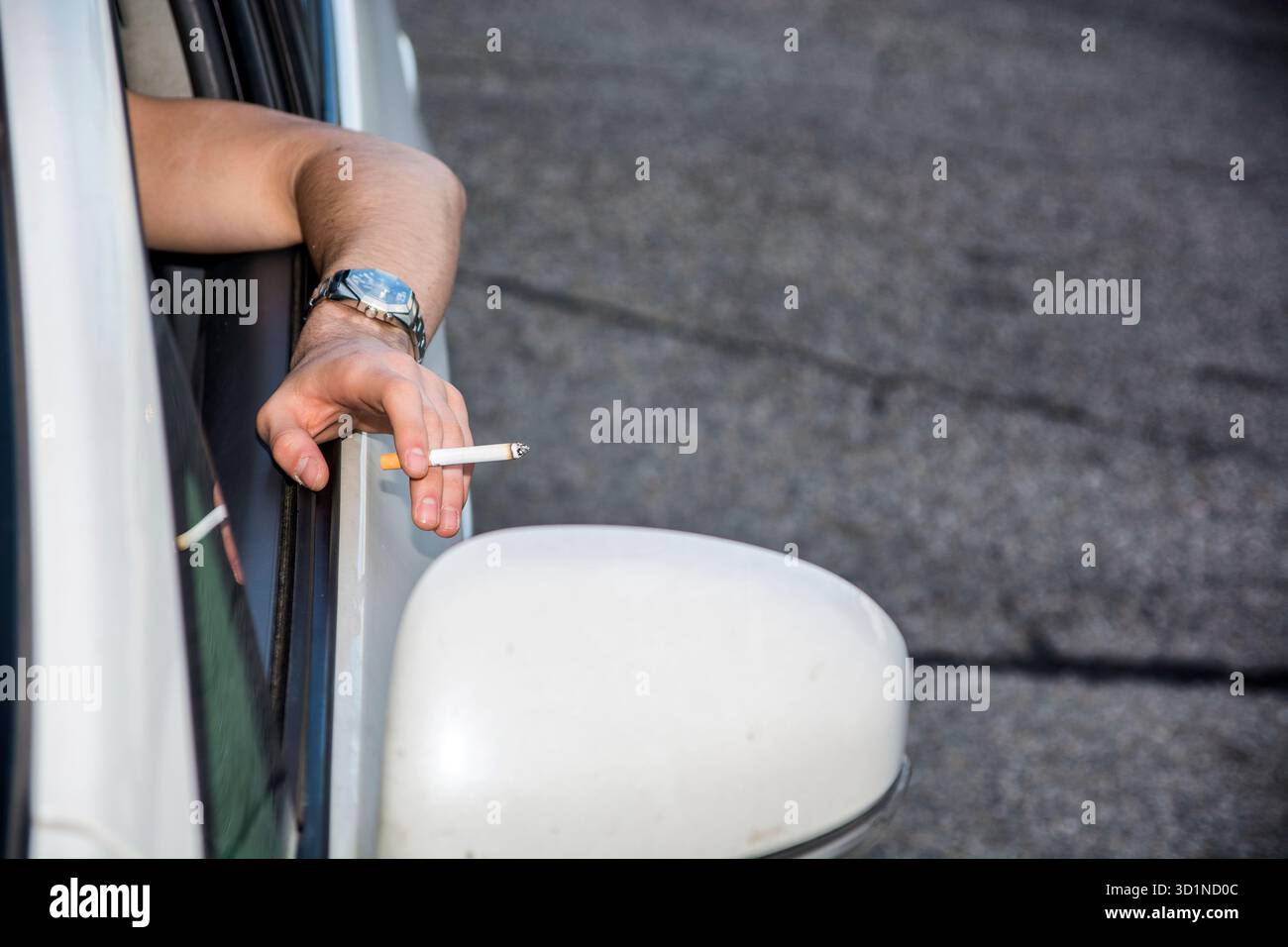 Young Man smoking cigarette while Driving Stock Photo - Alamy