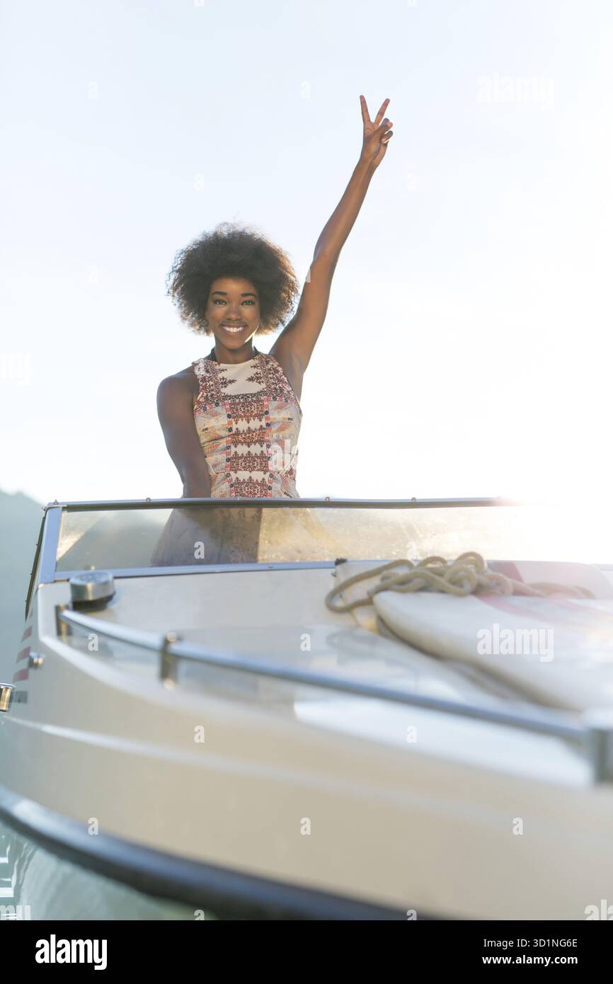 A stunningly beautiful afro woman driving a speedboat and having fun ...