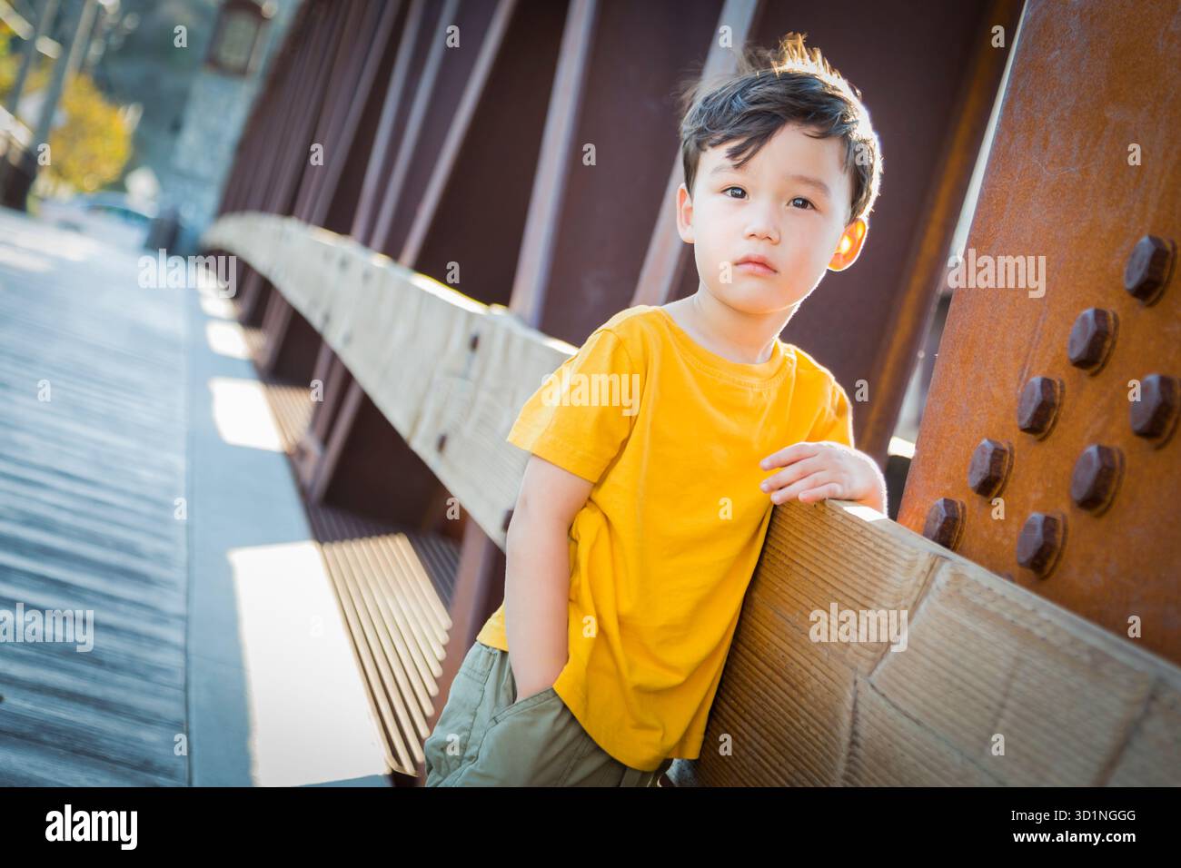 Handsome Mixed Race Boy Leaning on Bridge Outdoors Stock Photo - Alamy