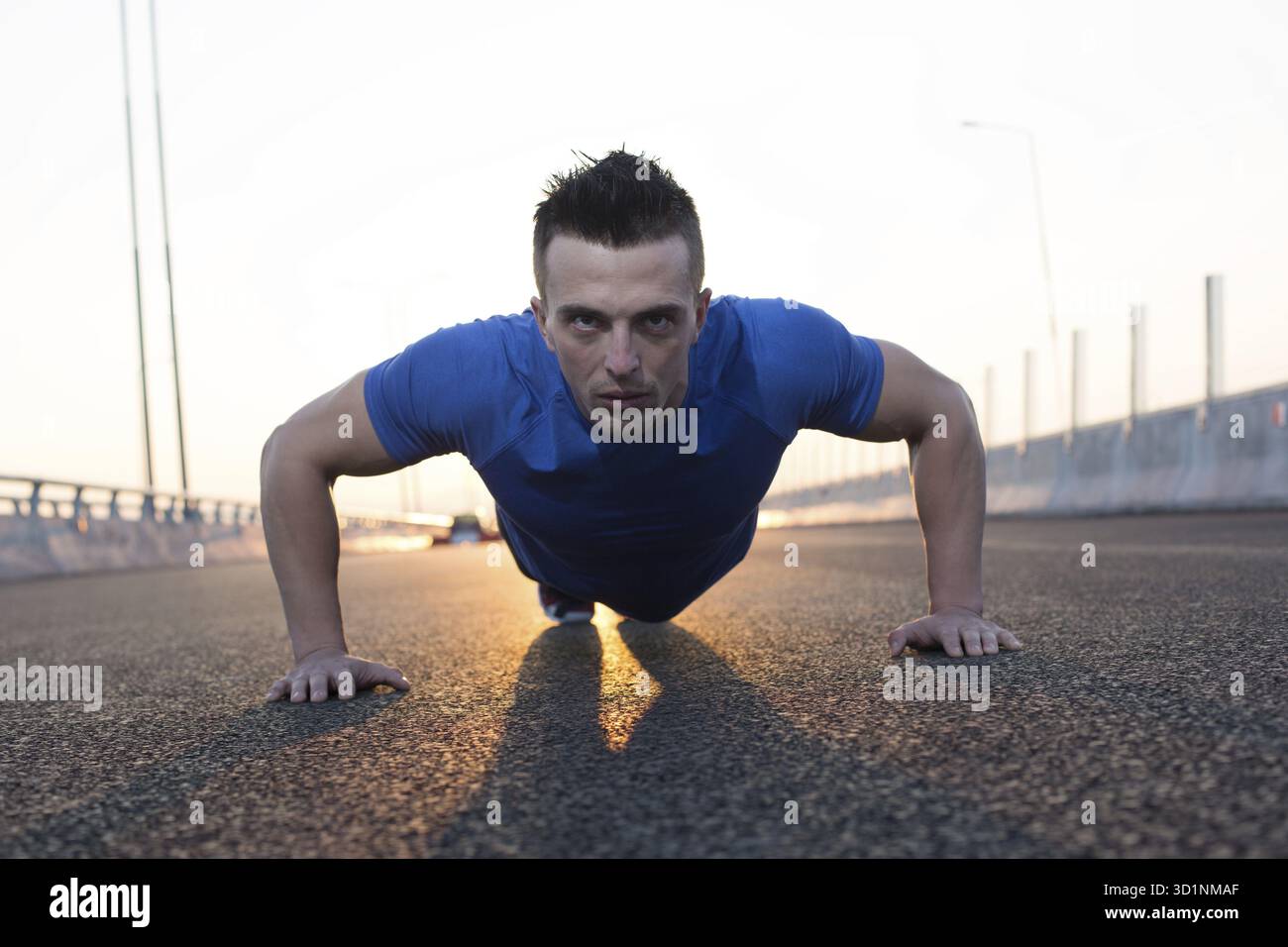 Handsome male runner doing push-ups on stairs in urban setting, young ...