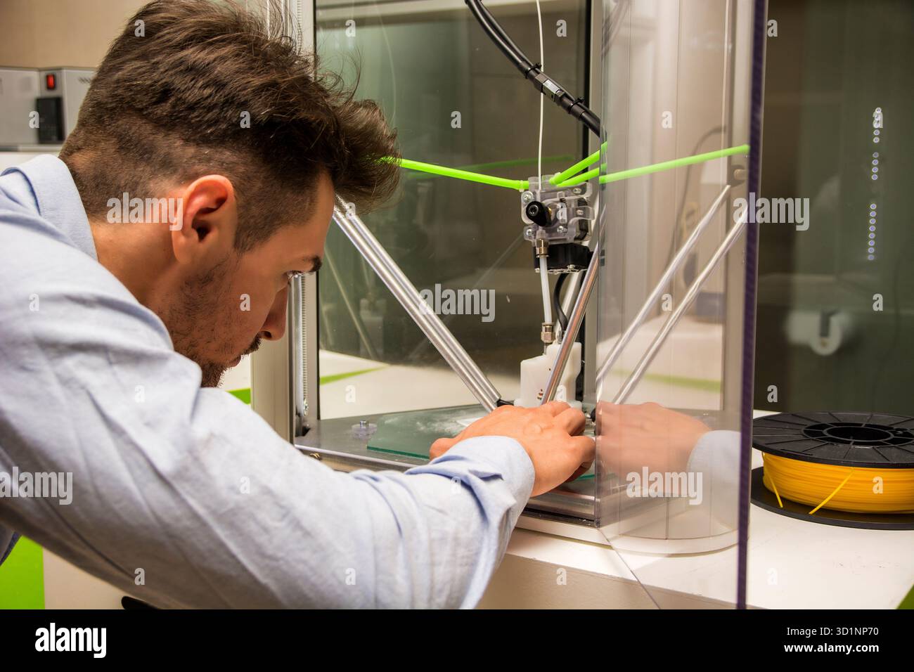 Man looking at 3d printer machine Stock Photo - Alamy