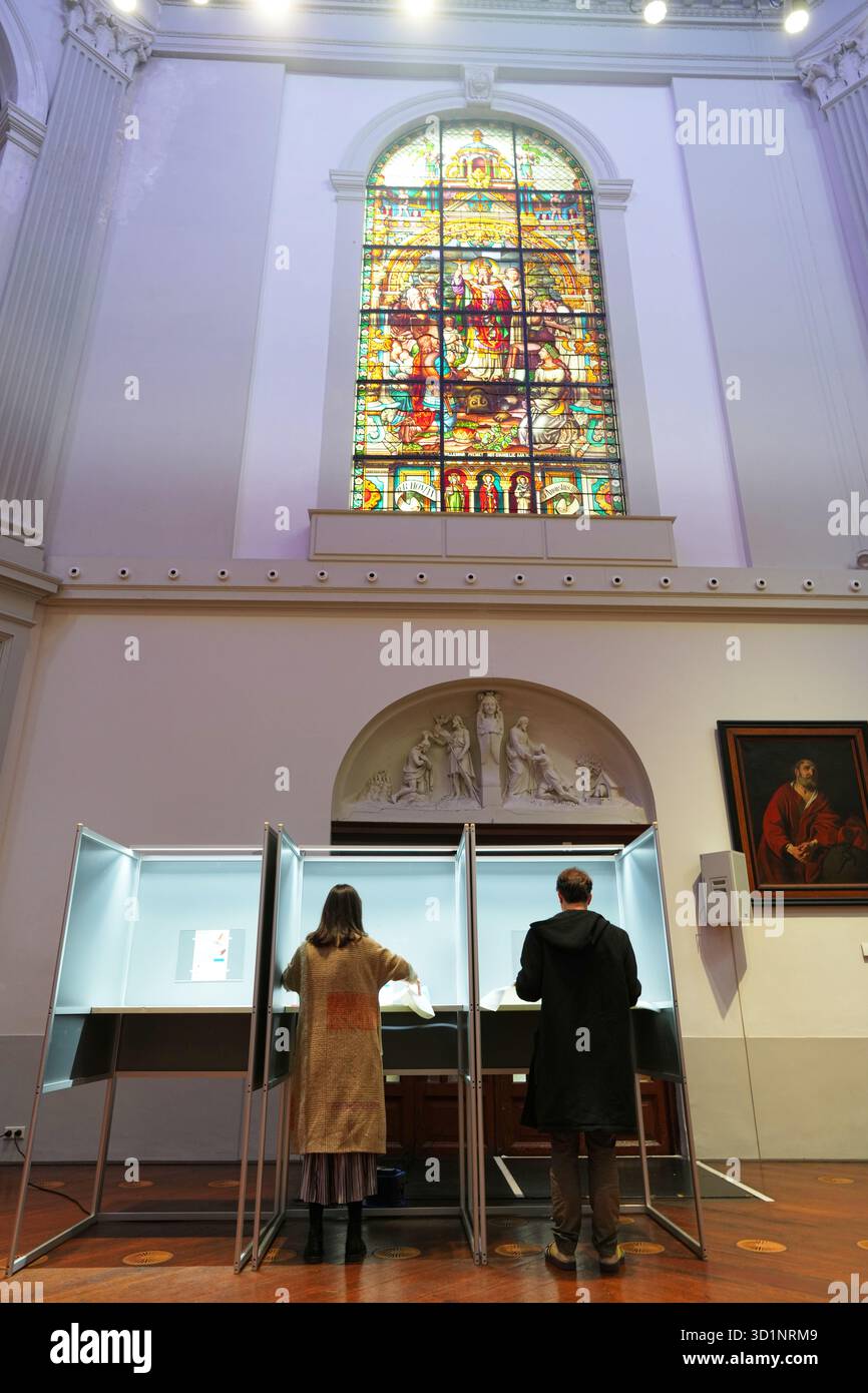 People stand in voting booths at De Duif church, which is operating as ...