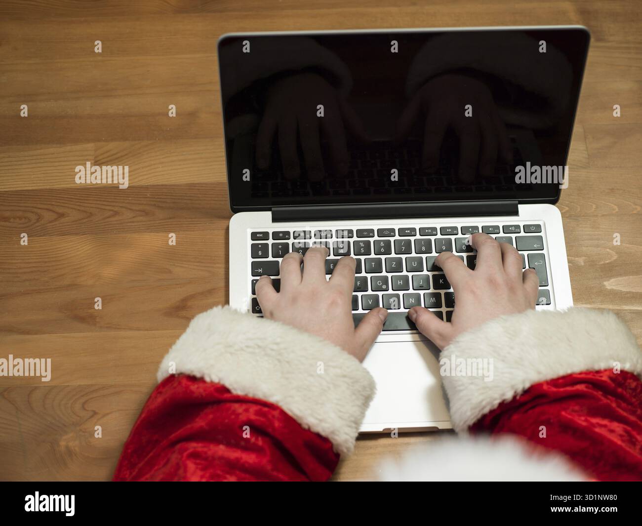 Santa working at desk and typing on a laptop, Christmas gifts and ...