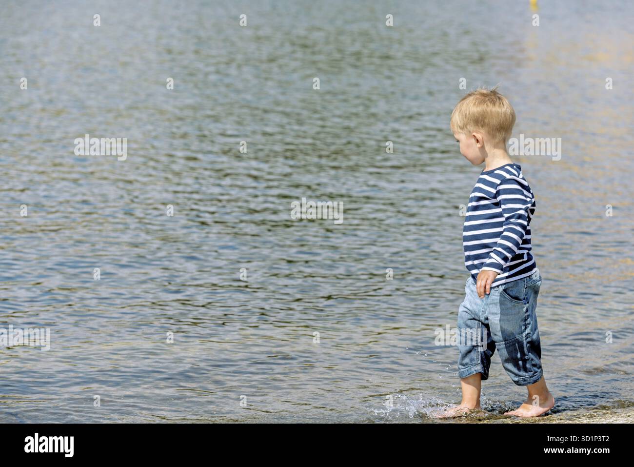 Little preschool boy walking on shore outdoors Stock Photo - Alamy