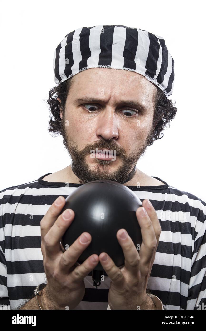 Funny man prisoner criminal with chain ball and handcuffs in studio ...