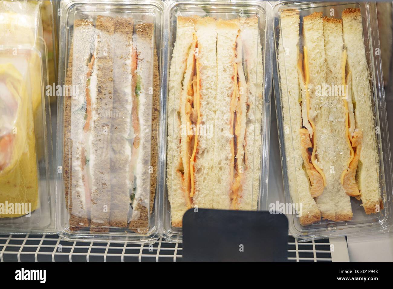 Sandwiches displayed on a shelf in a market with various fillings and ...