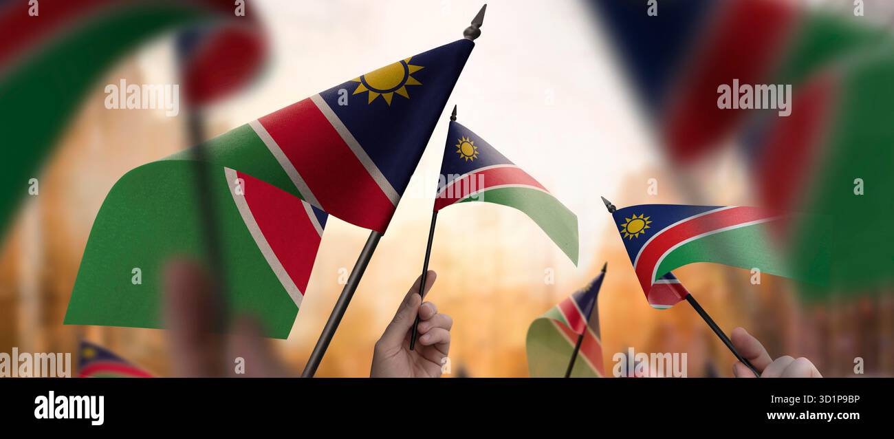 Namibia flags in their hands on a blurred urban background. The photo ...
