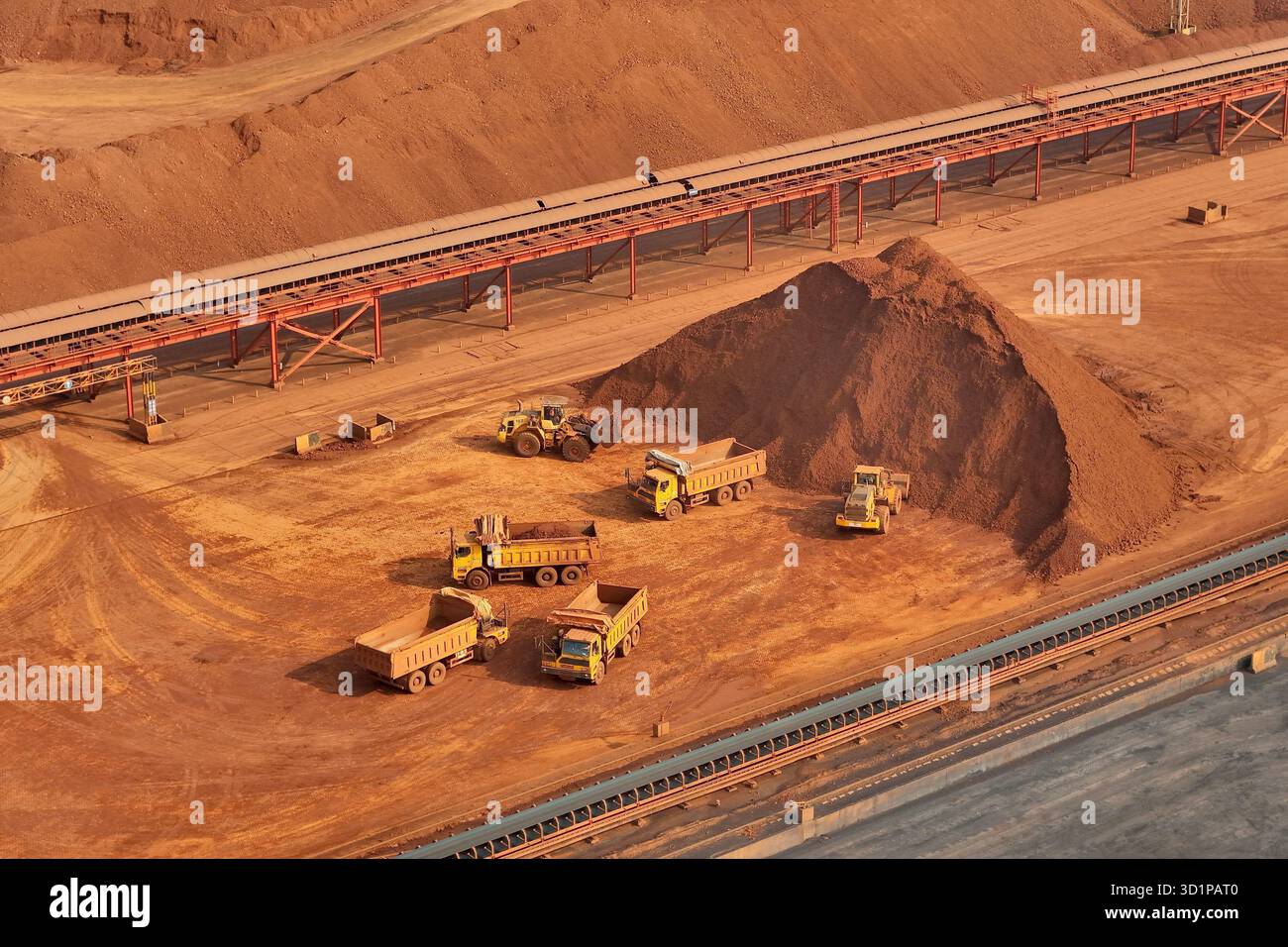 Loaders and trucks operate at a dock handling imported bauxite and iron ...