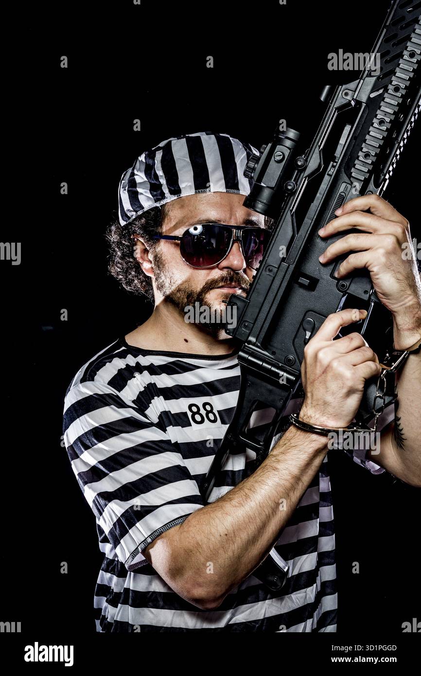 Violence .Prison riot concept. Man holding a machine gun, prisoner ...