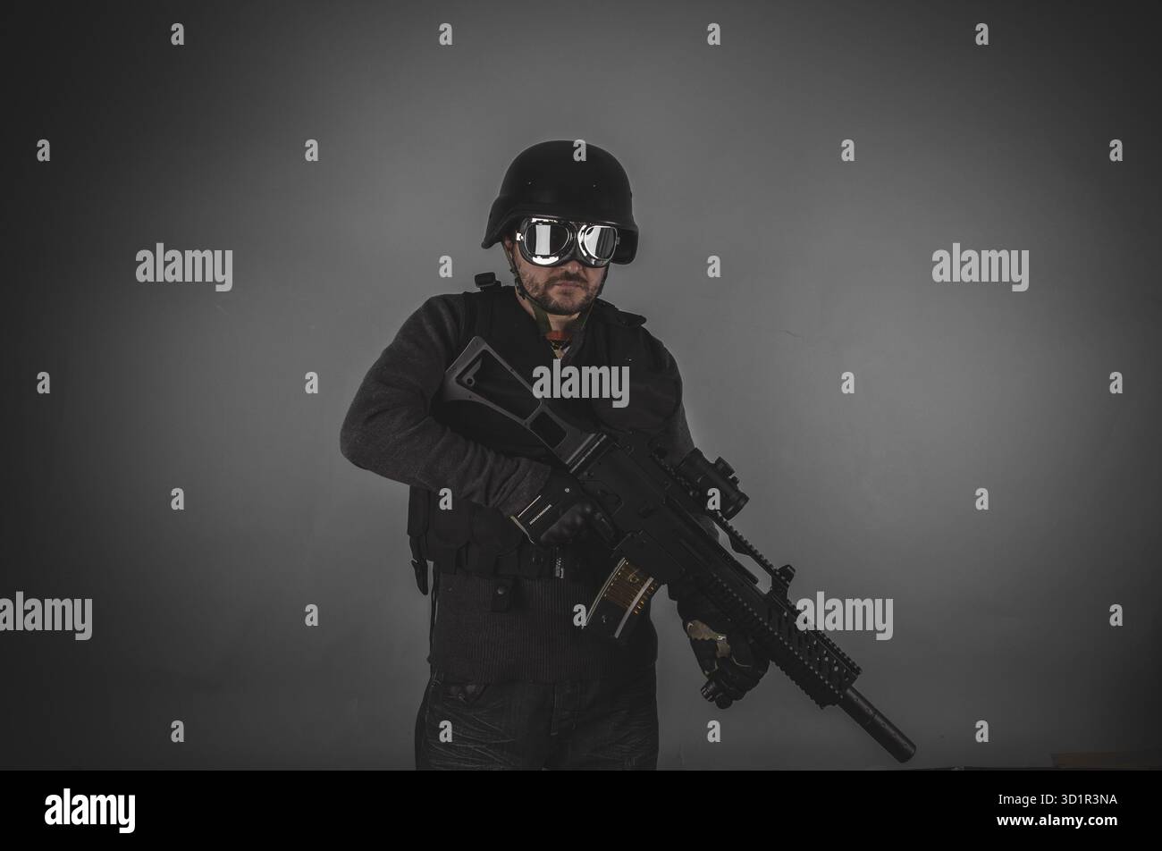 Sniper, airsoft player with gun, helmet and bulletproof vest on gray ...