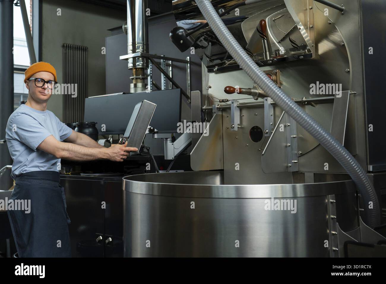 Modern coffee roasting factory, man operating process of creating ...