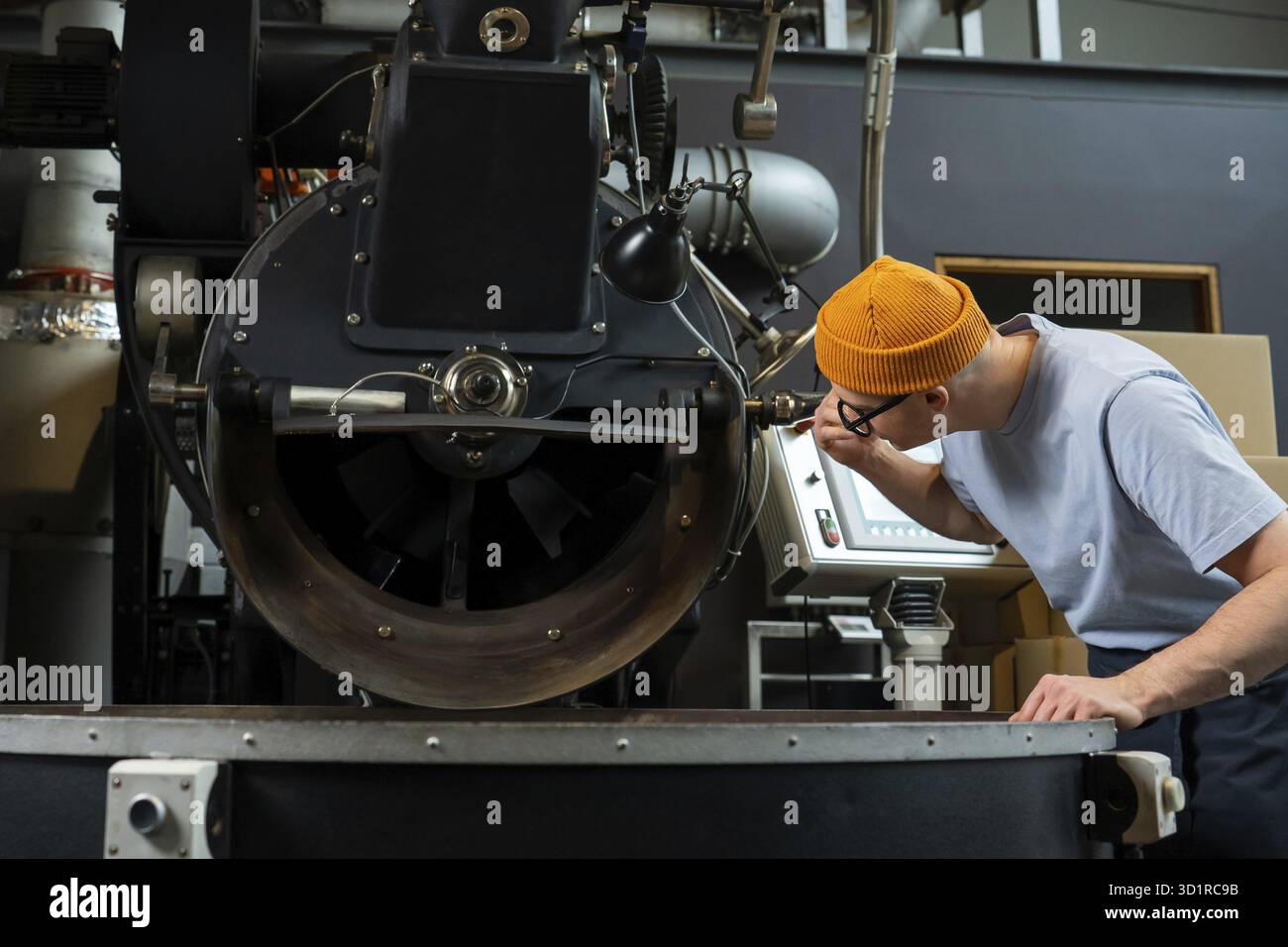Modern coffee roasting factory, man operating process of creating ...