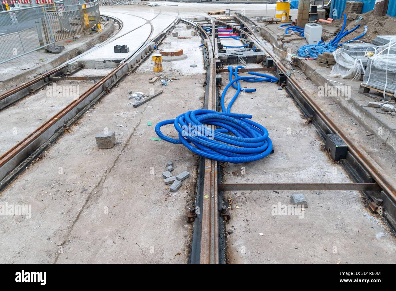 Urban tramway construction site with blue hoses and rails Stock Photo ...