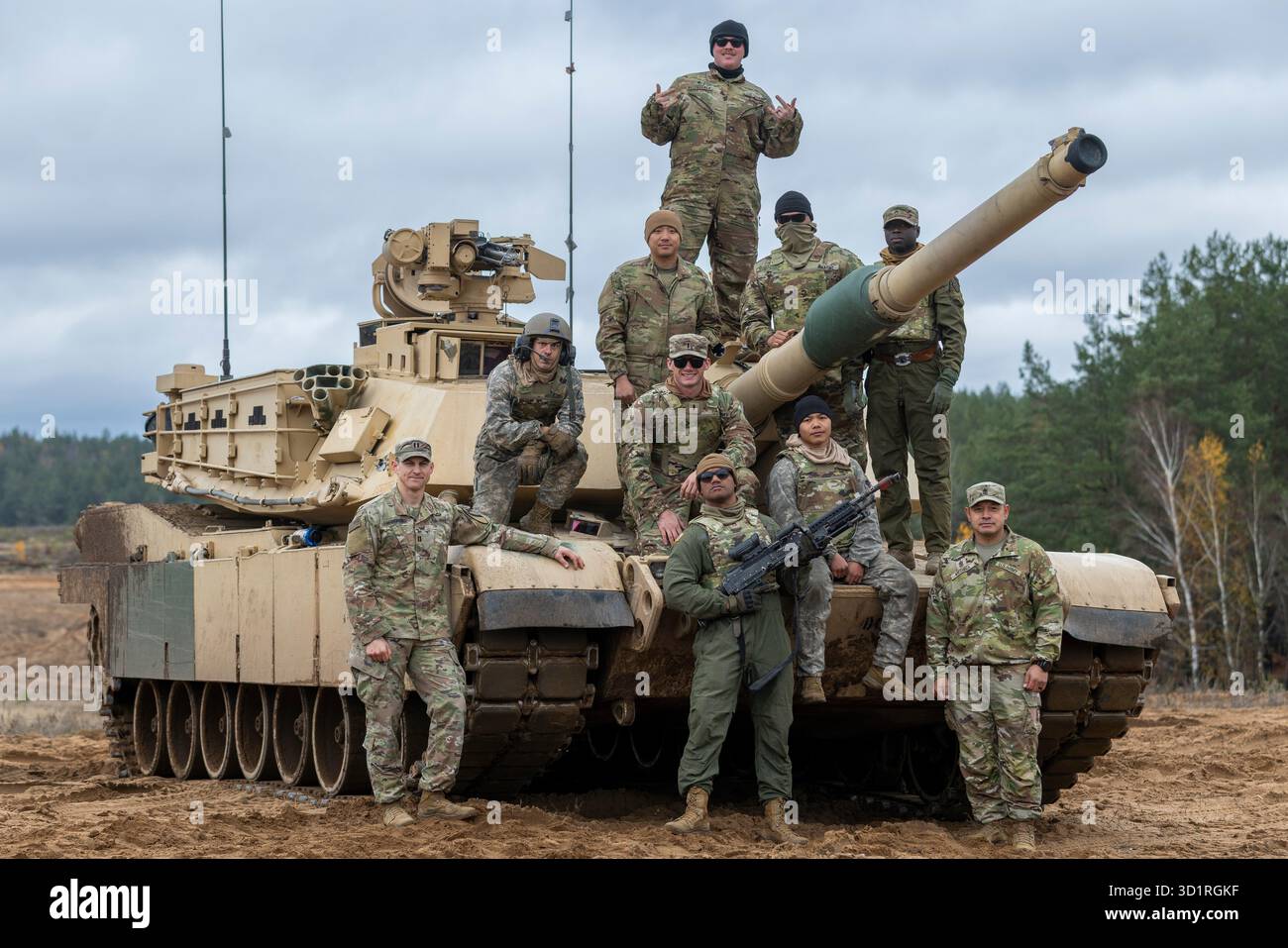 U.S. soldiers pose for a photo standing in front of their M1A2 Abrams ...