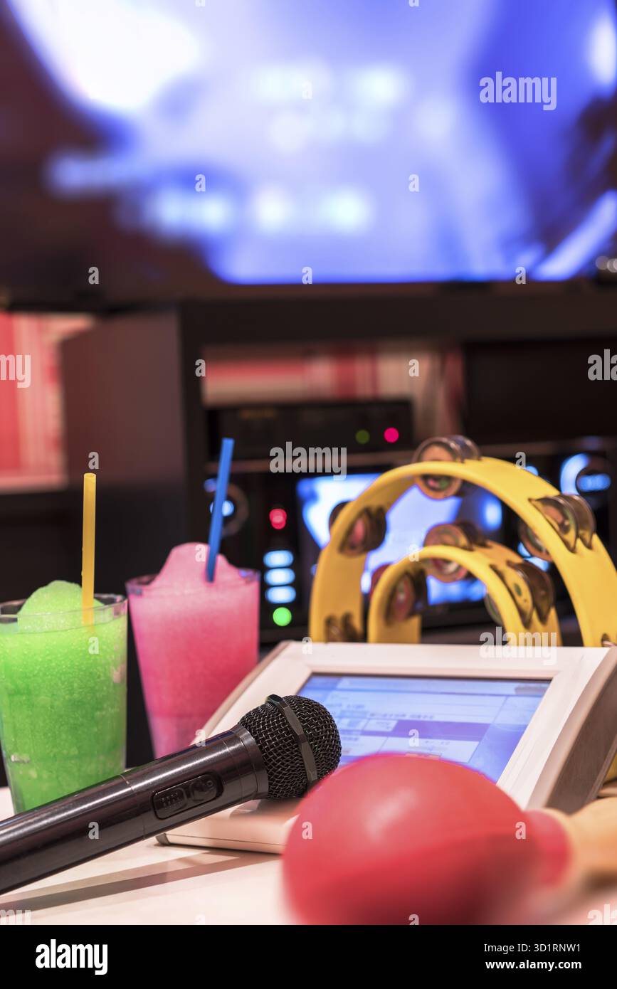 Black microphone in karaoke club, with remote controller, melon and ...