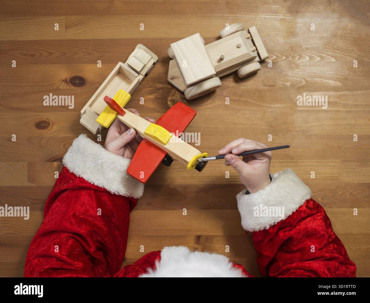 Santa Claus making toys. Painting and coloring wooden toy Stock Photo ...
