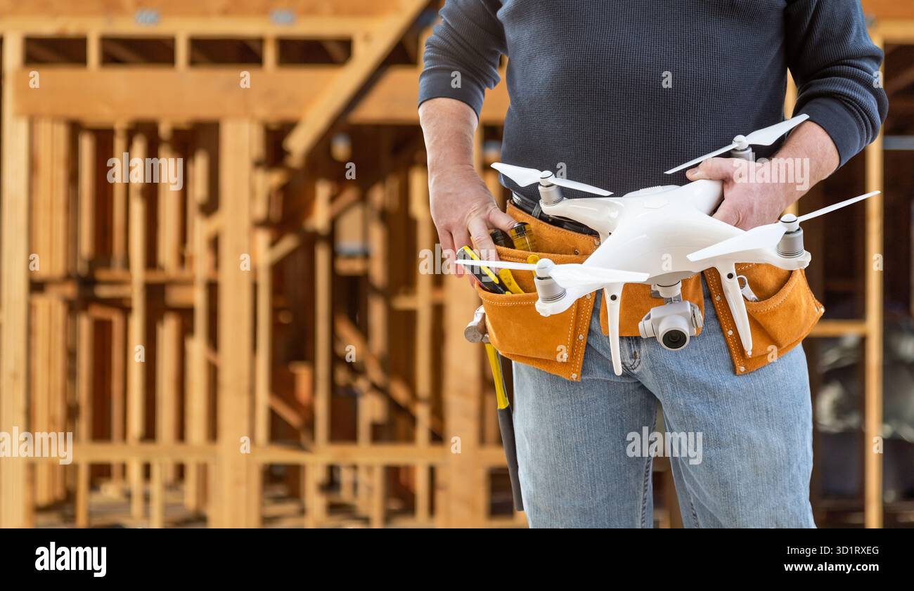 Construction Worker and Drone Pilot With Toolbelt Holding Drone At ...