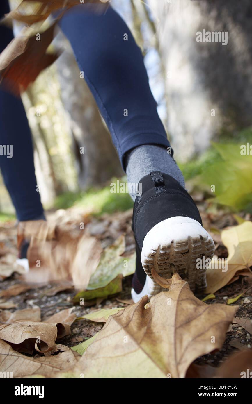 Close up of feet of a runner running in autumn leaves training for ...