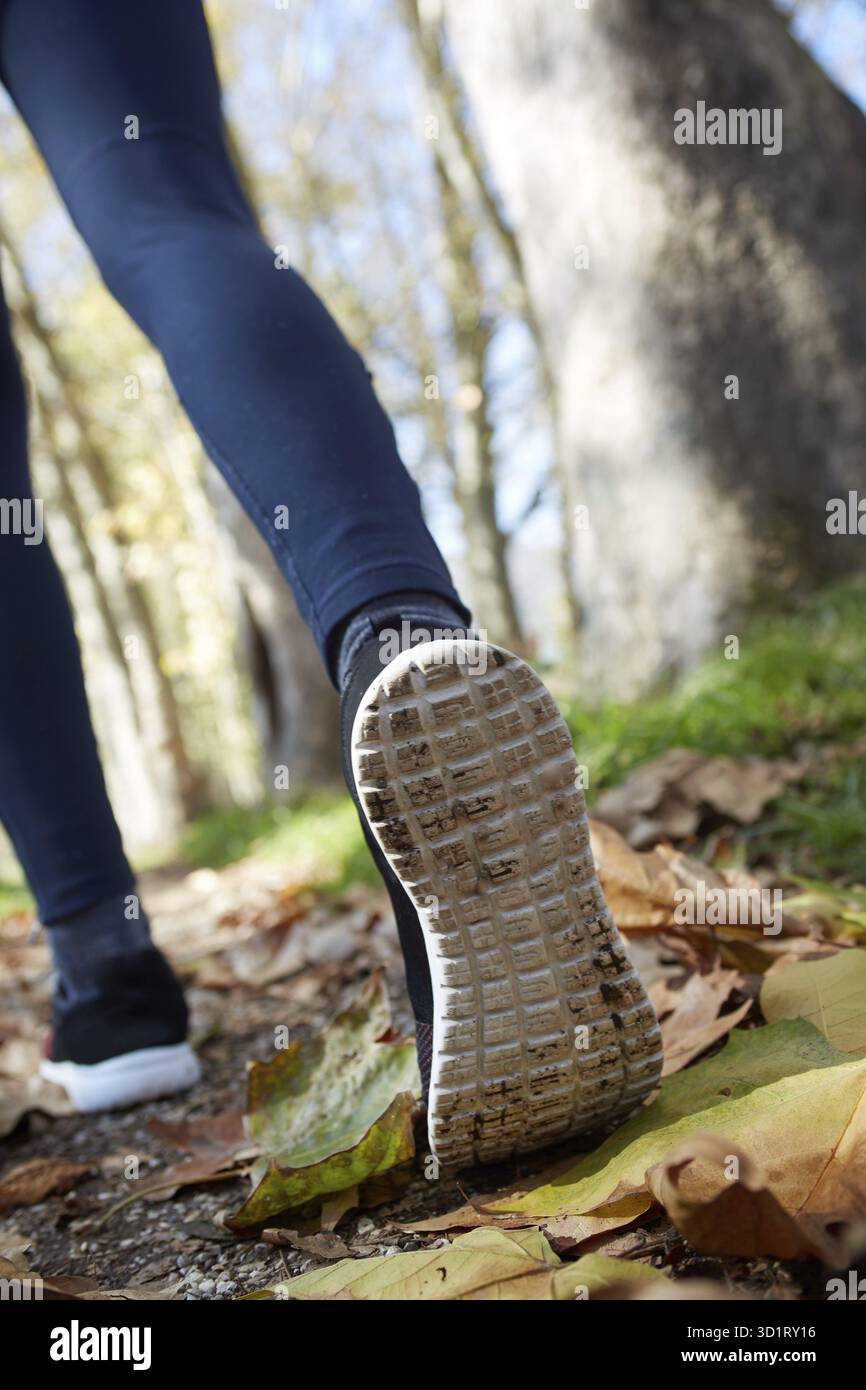 Close up of feet of a runner running in autumn leaves training for ...