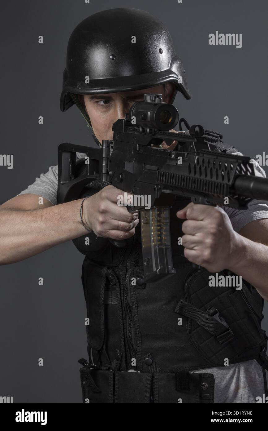 Playing, paintball sport player wearing protective helmet aiming pistol ...