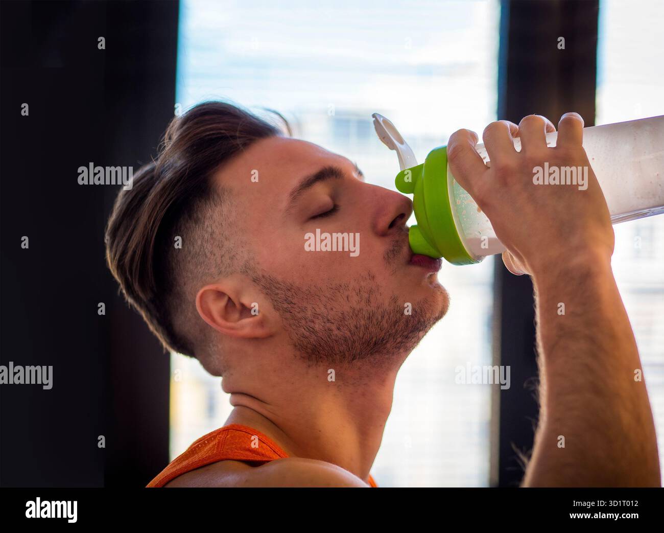 Young man drinking a smoothie drink or a protein shake Stock Photo - Alamy