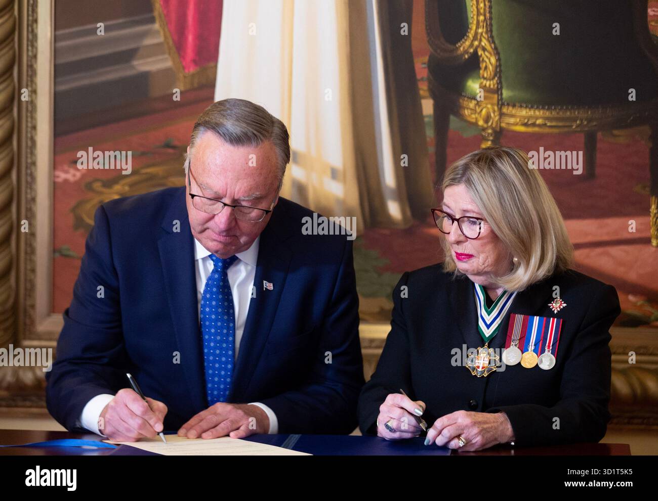 Newfoundland and Labrador Premier Tony Wakeham, left, signs his oath as ...