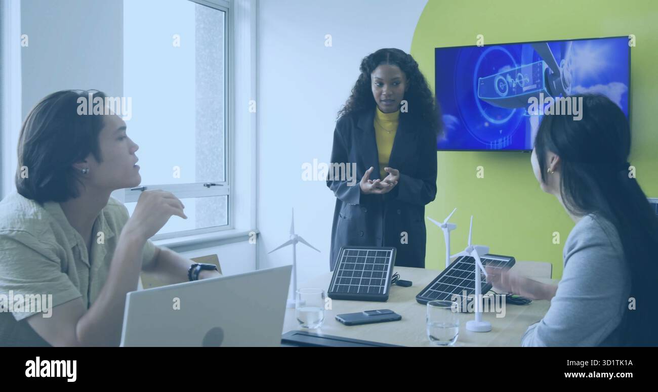 Presenting engineer in black blazer leading discussion at meeting table ...