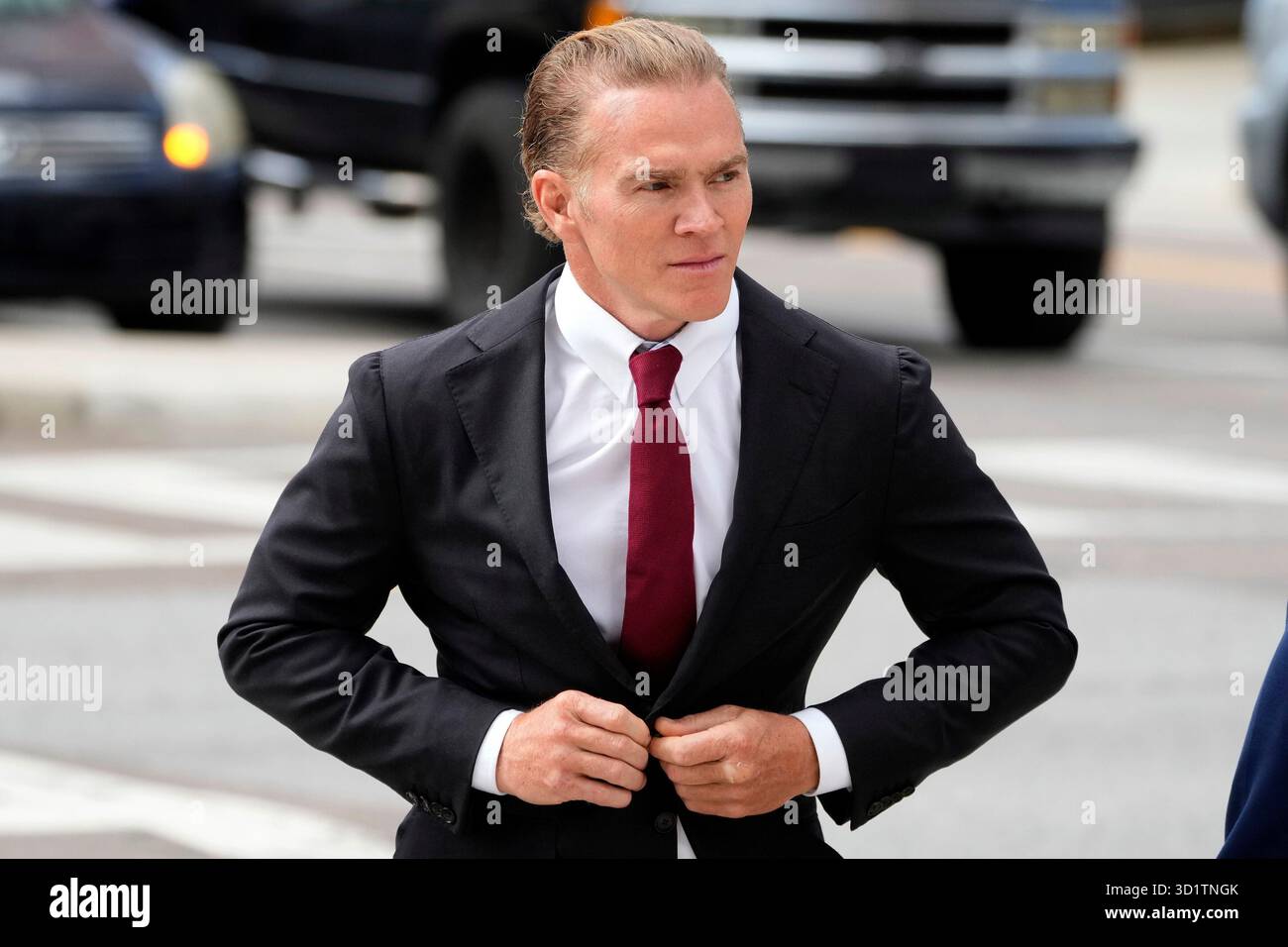 Former Green Beret Jordan Goudreau buttons his suit jacket as he walks ...